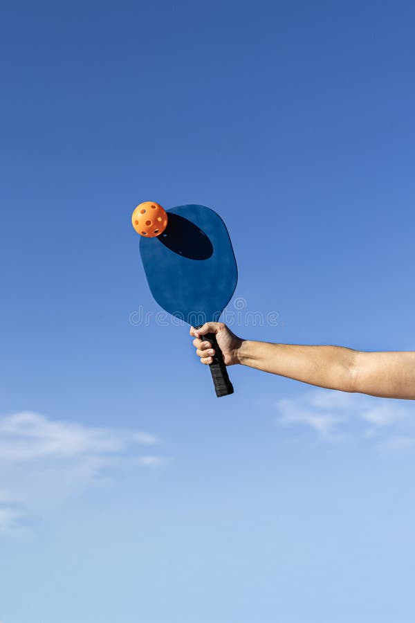Arm with Blue Paddle Hitting Orange Pickleball Ball Stock Photo - Image ...
