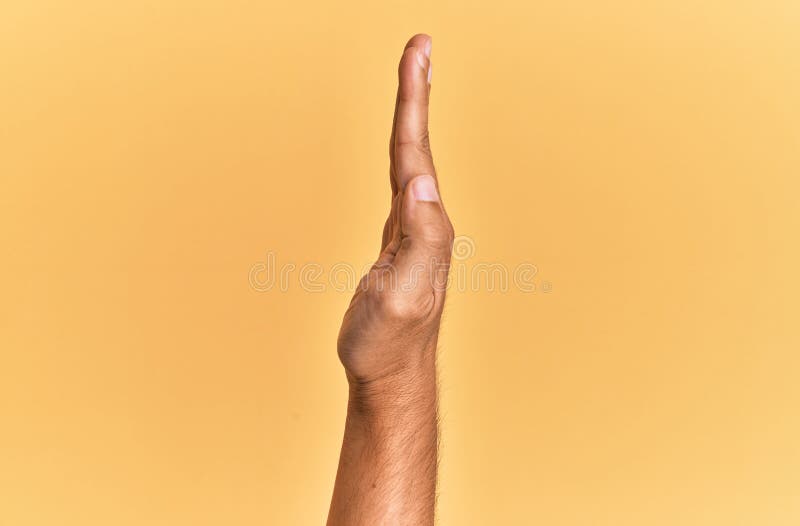 Arm and Hand of Caucasian Man Over Yellow Isolated Background Showing ...