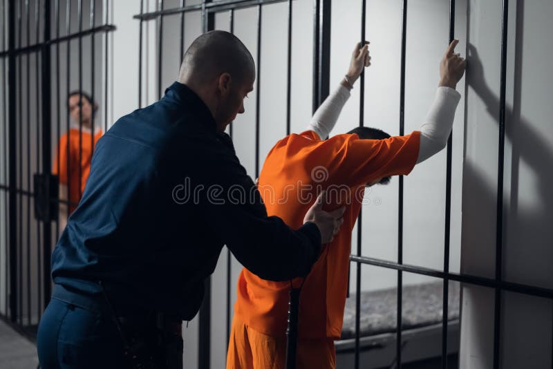 An Armed Guard Searches a Newly Arrived Criminal in a Prison Corridor ...