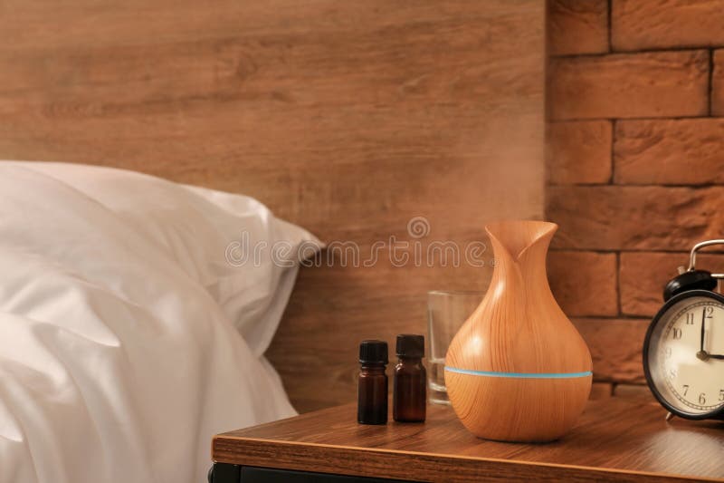 Aroma Oil Diffuser with Bottles on Table in Bedroom Stock Photo - Image ...