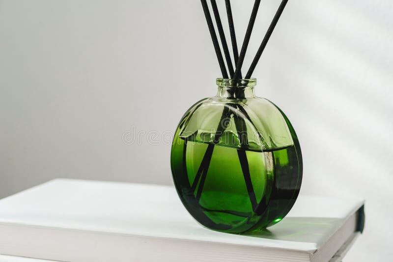 Aromatic Reed Diffuser on White Books with Shadows Playing on the Wall ...
