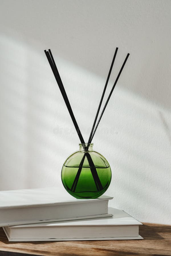 Aromatic Reed Diffuser on White Books with Shadows Playing on the Wall ...
