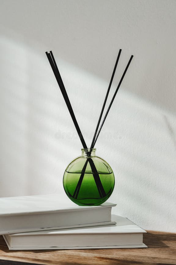 Aromatic Reed Diffuser on White Books with Shadows Playing on the Wall ...