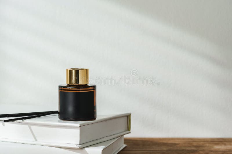 Aromatic Reed Diffuser on White Books with Shadows Playing on the Wall ...