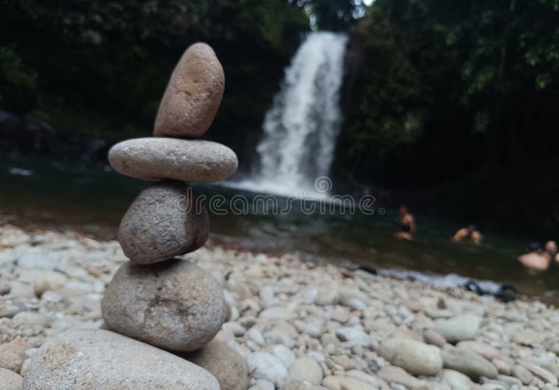 An Arrangement of River Stones with Waterfall in the Background Stock ...