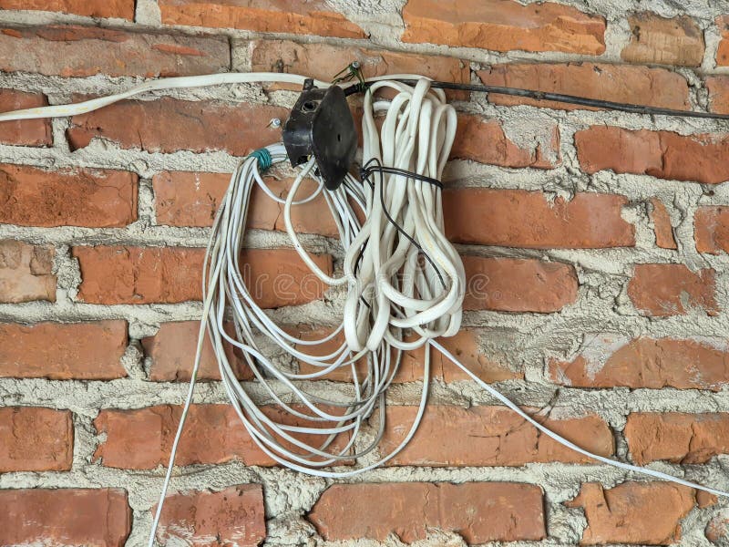 An Arrangement of Tangled Electrical Wires on a Rustic Brick Wall ...