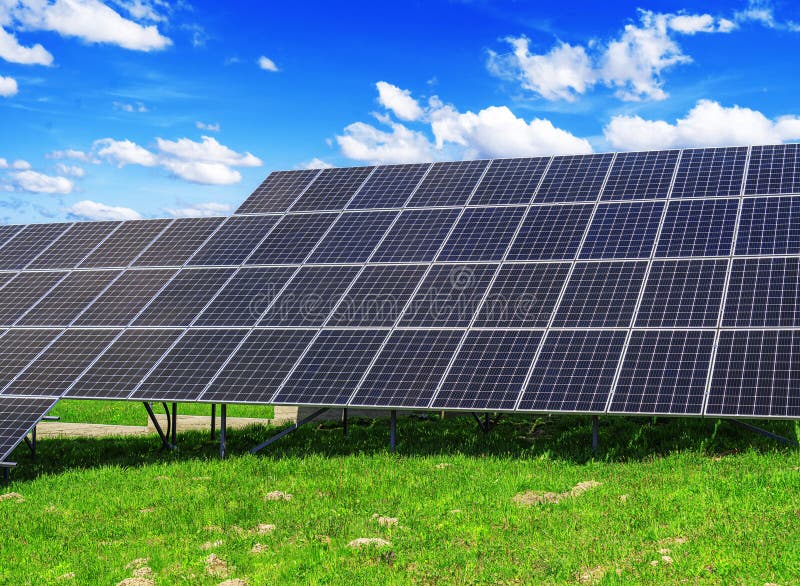 Array of Solar Panels Installed on a Green Grassy Field Under a Bright ...