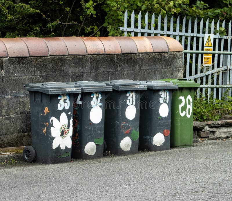 Row of Wheeled Trash Bins Lined Up Side by Side on a Paved Sidewalk ...