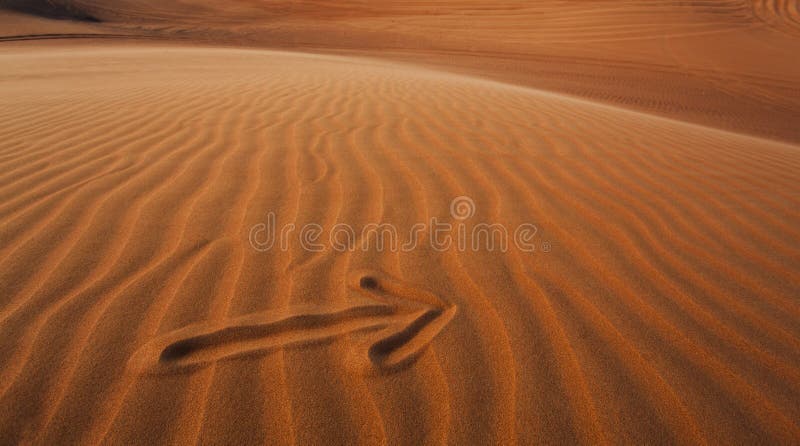 Arrow in the desert sand stock image. Image of direction - 131996421