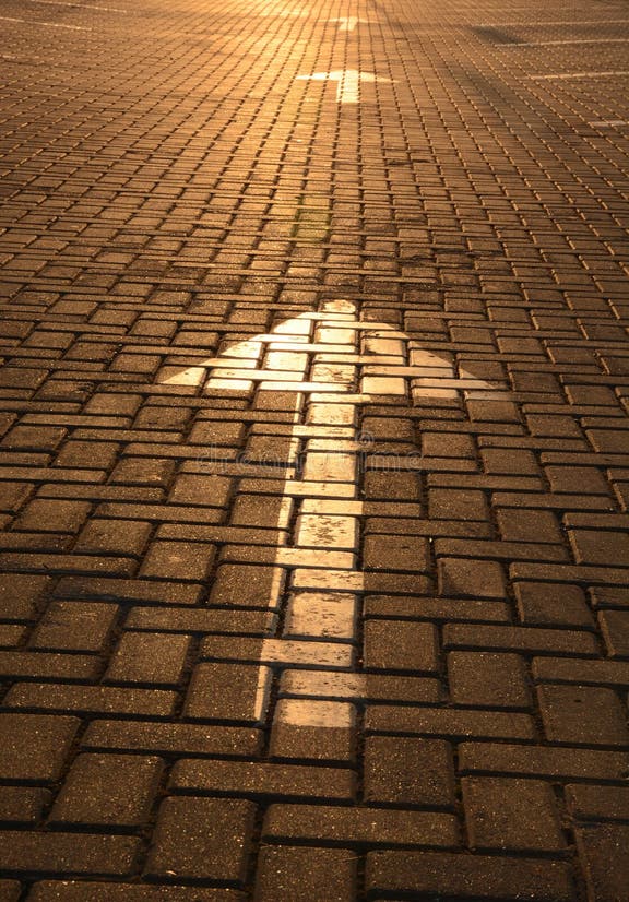 Arrow on a Road Tile in the Rays of the Setting Sun Stock Image - Image ...