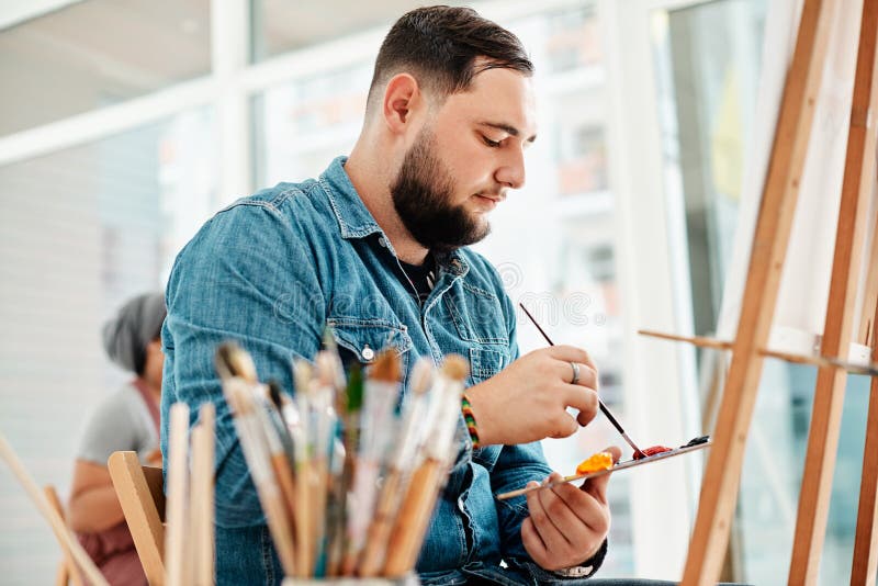 Art is Life. a Handsome Young Artist Sitting and Painting during an Art Class in the Studio ...