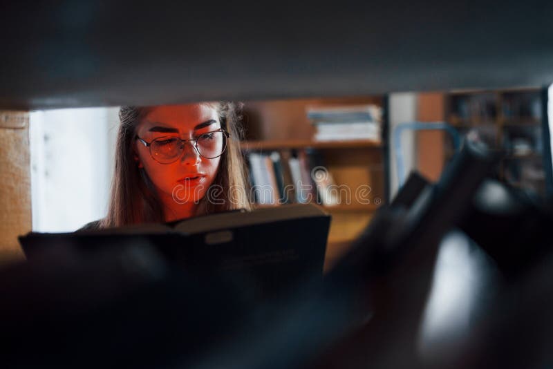 Artificial Red Light on from the Book. Female Student is in Library ...