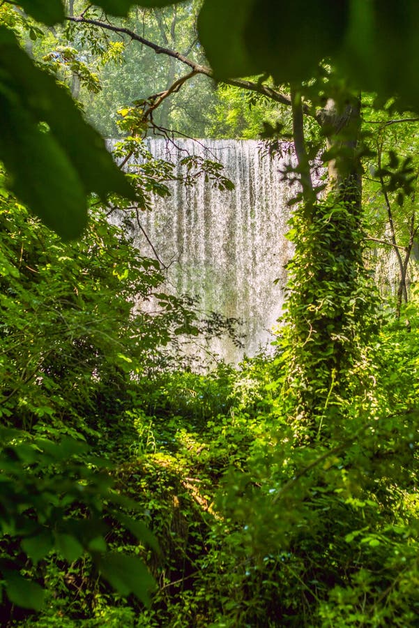 An Artificial Waterfall with a High Drop Nestled Stock Photo - Image of ...