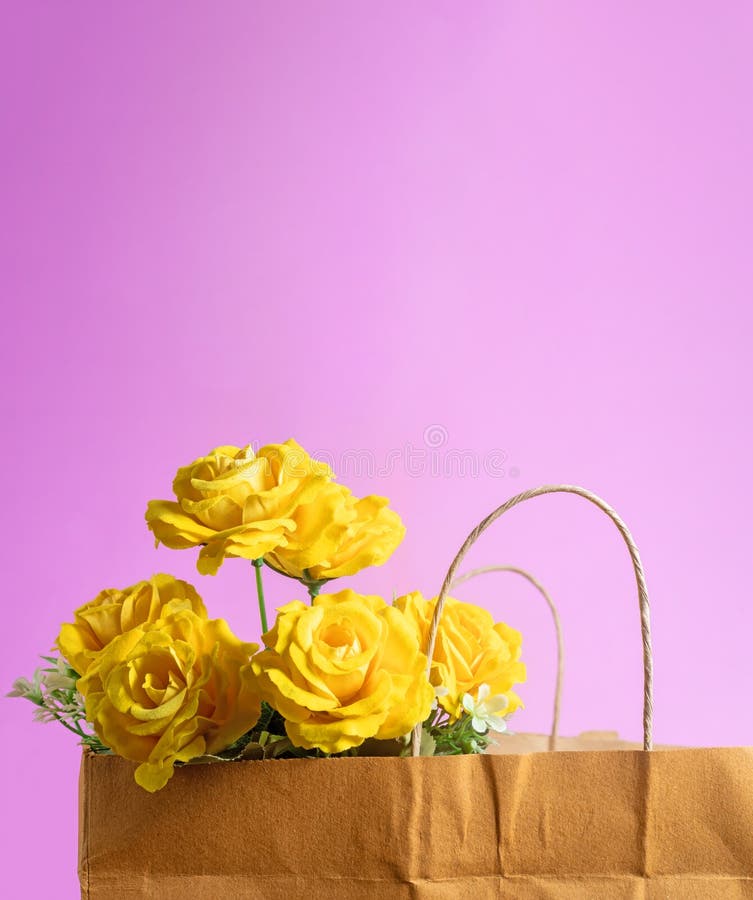 Artificial Yellow Roses in a Paper Bag on a Pink Background, Copy Space ...