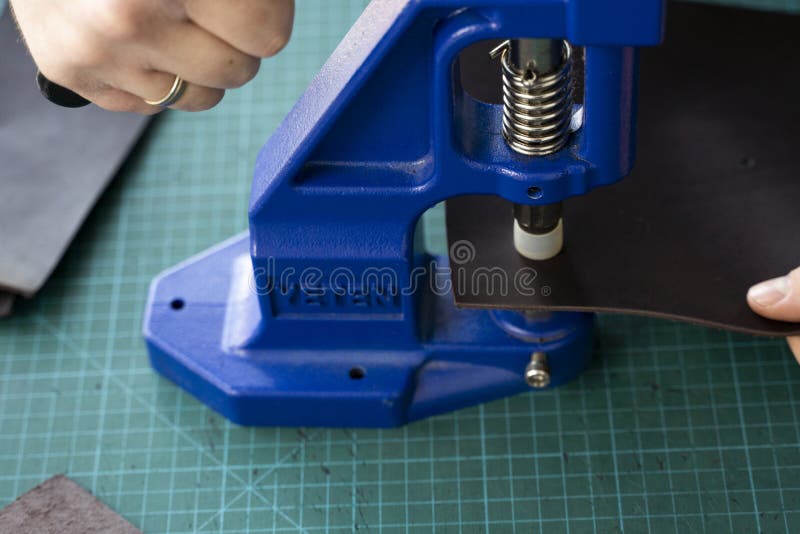 Artisan Using Hand Press for Setting Snaps in Leather for Makes a ...