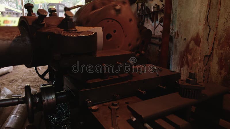 Artisan Using a Lathe Machine in a Rustic Workshop with Tools on the ...