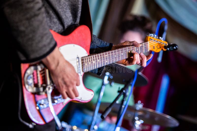 Man Playing Red And Black Electric Guitar On Stage Picture. Image: 82933716