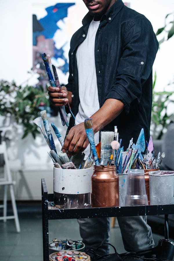Artist in Slick Clothes Sorting His Brushes and Tools, No Face. Stock ...