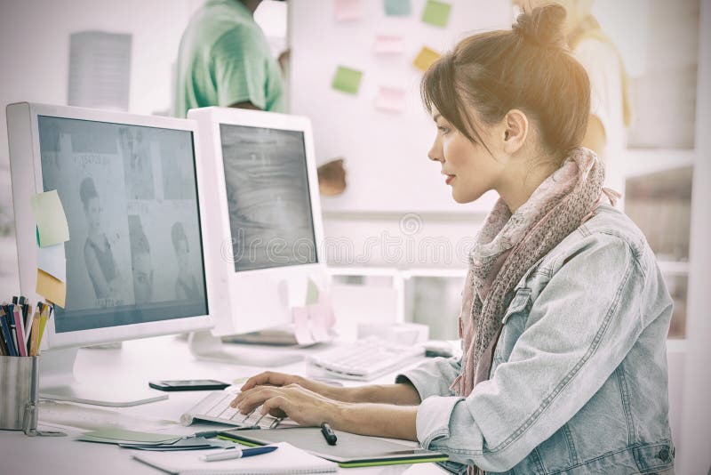 Artist Using Computer with Colleagues Behind at Office Stock Image ...