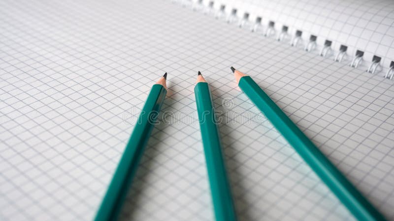 Artistic Arrangement of Green Pencils on a Checkered Notebook Paper ...