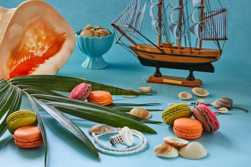 An Artistic Display on a Blue Table with Seashells, Macarons, and a ...