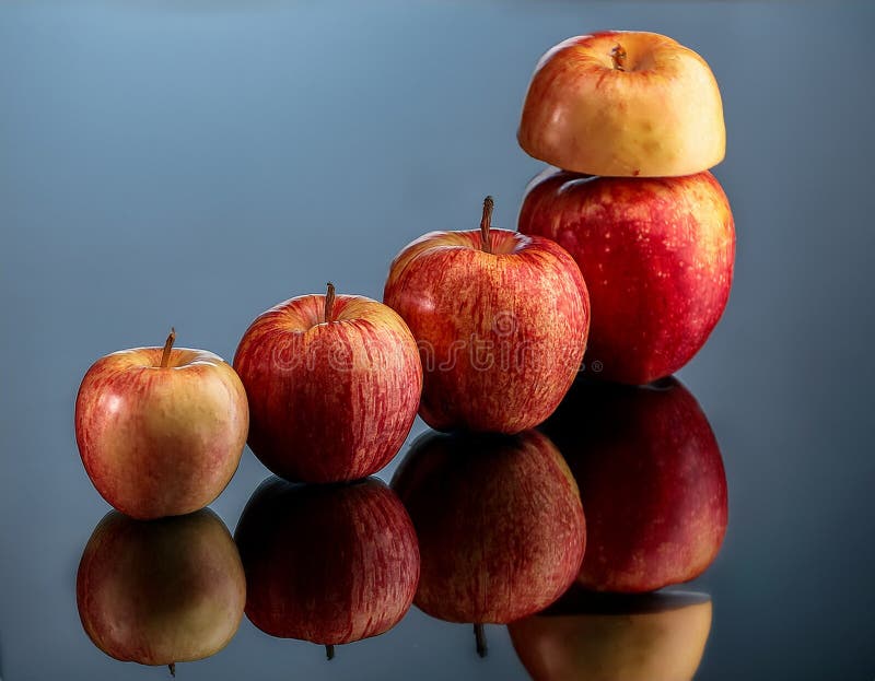 An Artistic Row of Stacked Apples from Smallest To Largest on a Smooth ...