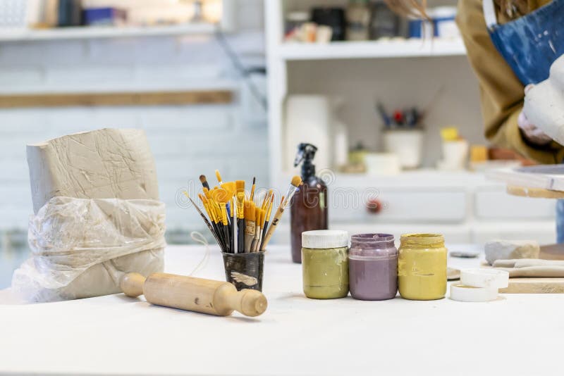 Artistic Workspace Filled with Pottery Tools and Vibrant Paint Pots ...