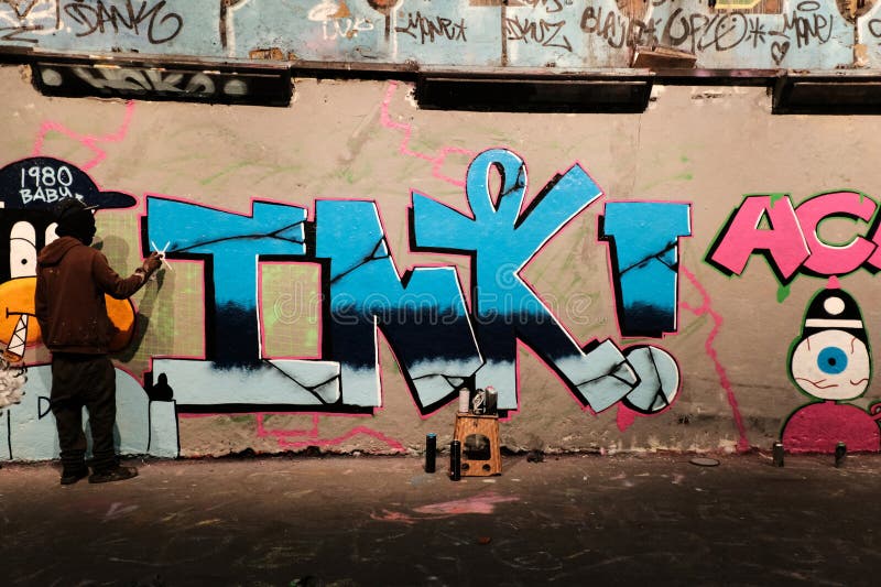 Urban Graffiti Scene Shows a Street Artist Painting a Large, Colourful ...