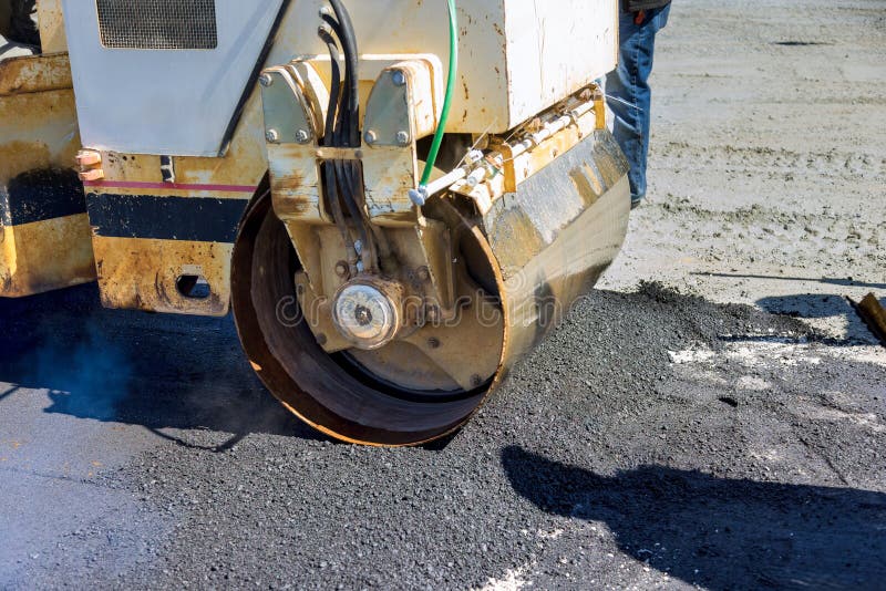 As Asphalt is Being Laid on a New Road Worker Uses an Asphalt Roller ...