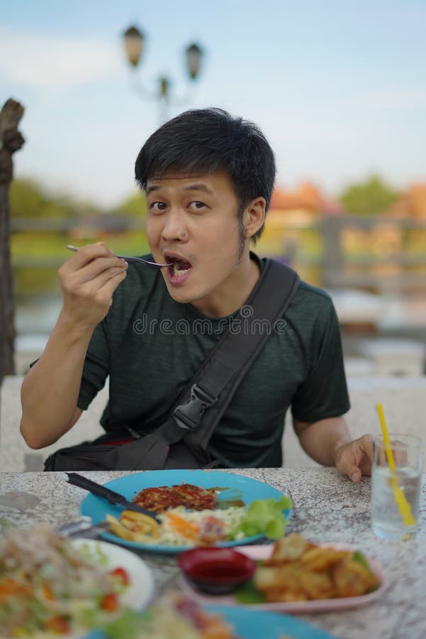 Asain Man Eating Chicken Steak at Riverside Stock Image - Image of ...