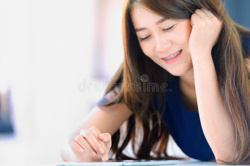 Asia Smile Girl Lying on Floor and Looking into Tablet Computer Stock ...