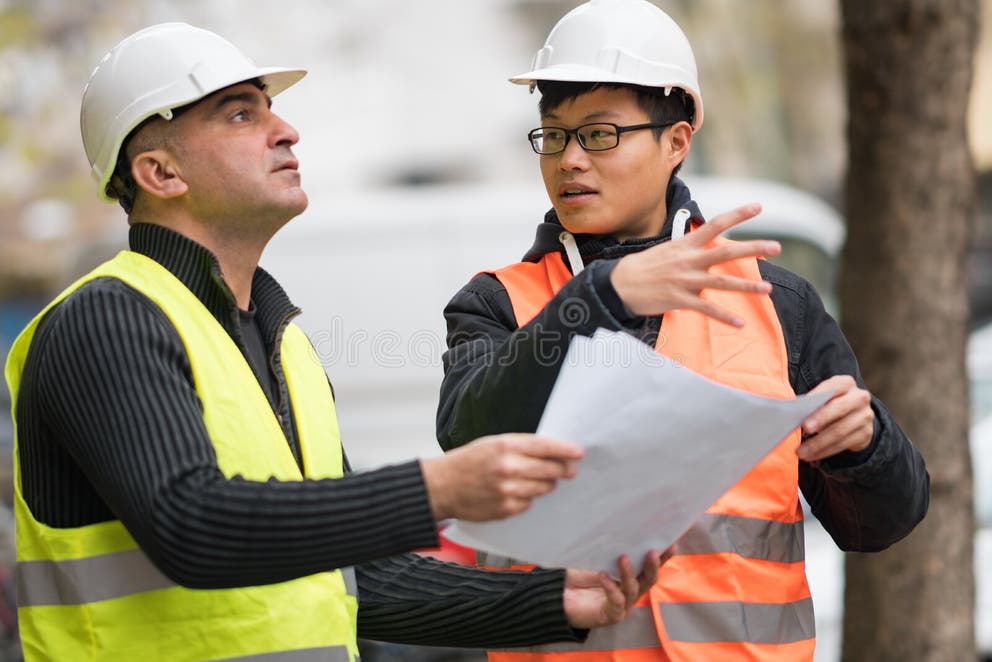 Asian Apprentice Engineer at Work on Construction Site with the Senior ...