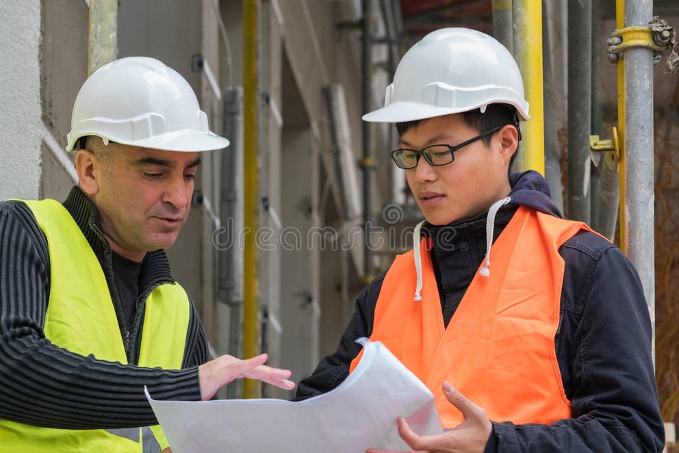 Asian Apprentice Engineer at Work on Construction Site with the Senior ...