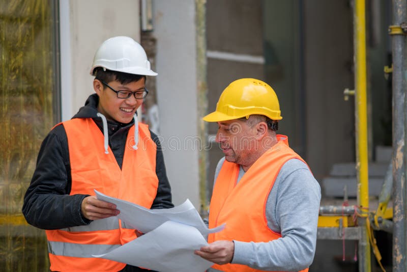 Asian Apprentice Engineer at Work on Construction Site with the Senior ...