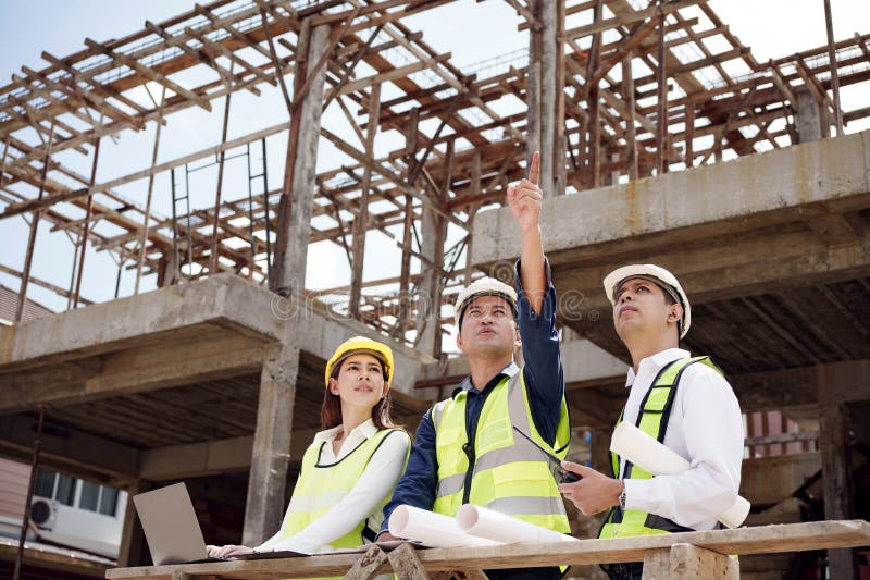 Asian Architector and Engineers Team with Draft Plan of Building and ...