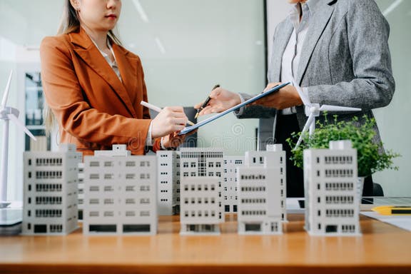 Asian Architects and Developers in a Modern Office Collaborate Using Building Models and Digital ...