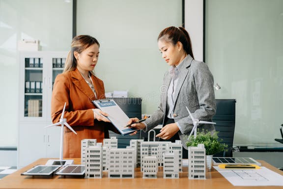 Asian Architects and Developers in a Modern Office Collaborate Using Building Models and Digital ...