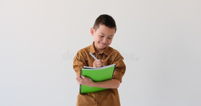 Young Asian Boy Taking Notes in a Notebook on White Background Stock ...
