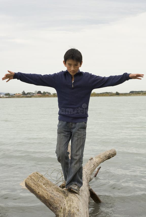 Asian Boy Balancing on Log Over Water Stock Photo - Image of asian ...