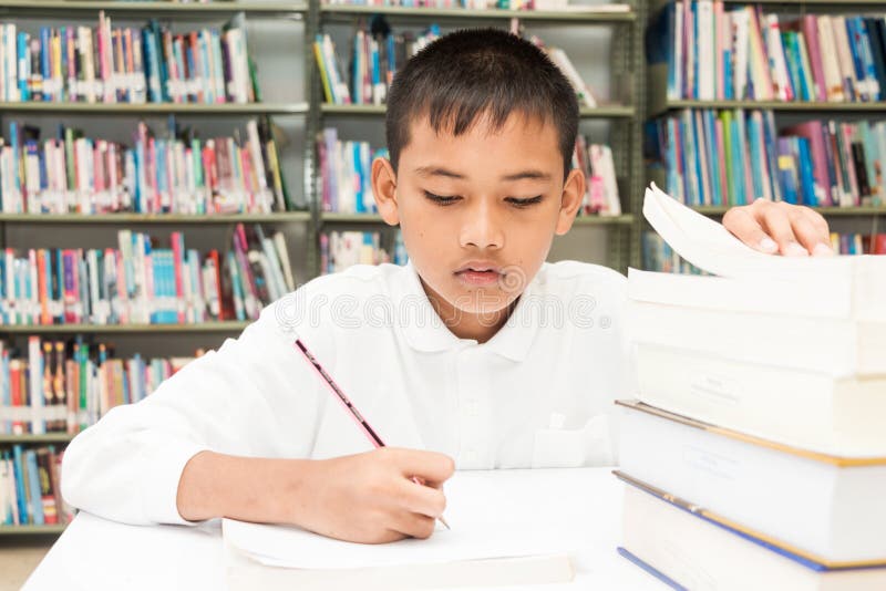 Asian boy doing homework . stock photo. Image of desk - 121625362