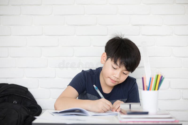 Asian Boy Doing Homework Near White Brick Wall Stock Image - Image of ...