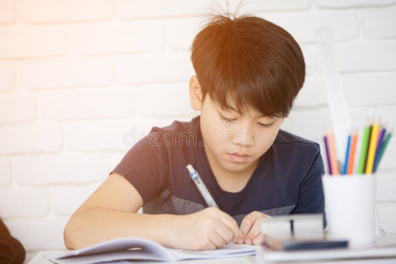Asian Boy Doing Homework Near White Brick Wall Stock Image - Image of ...