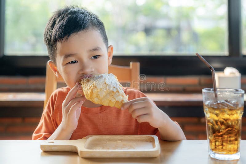 Asian Boy Eating Sweet Croissant in Restaurant with Beverage Stock ...