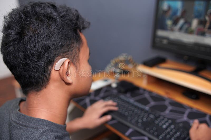 Asian Boy with Hearing Aid Device Using Computer Stock Photo - Image of ...