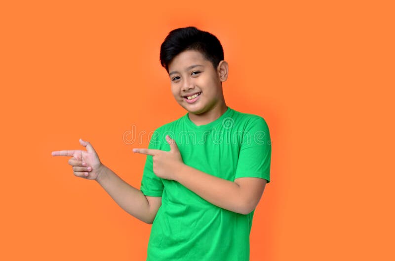 Asian Boy with Pointing Something Expression. Isolated at Orange ...