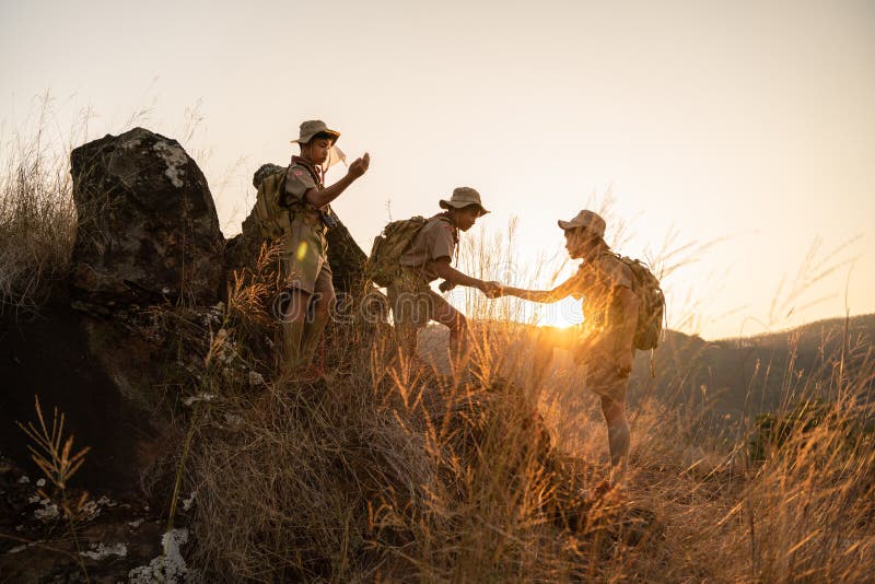 Asian Boy Scouts Help Pull Up from the Cliff. Unity and Teamwork ...