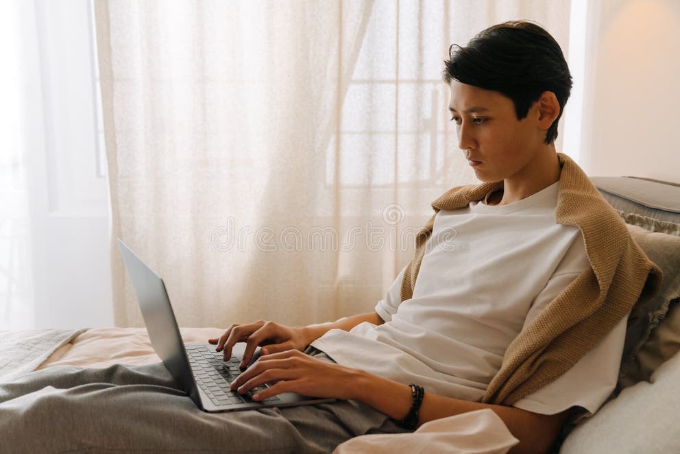 Asian Boy Working with Laptop while Resting on Bed Stock Photo - Image ...