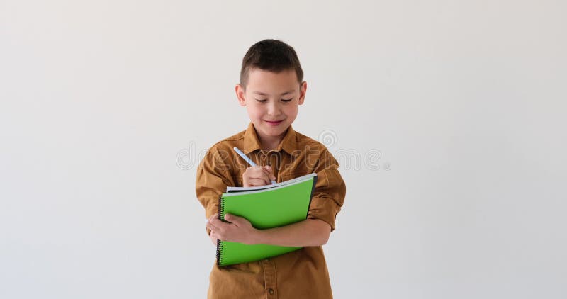 Young Asian Boy Taking Notes in a Notebook on White Background Stock ...