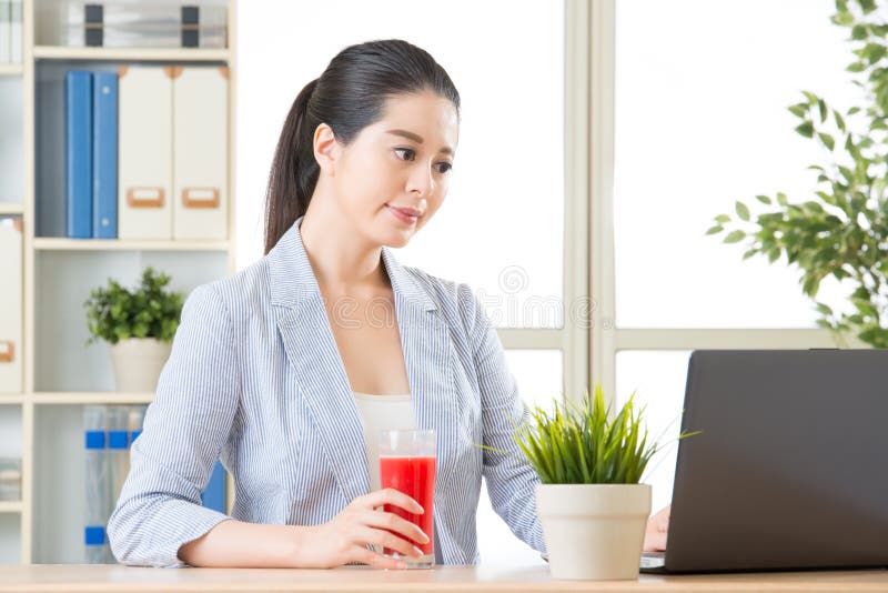 Asian Business Woman Drinking Watermelon Juice and Use Computer Stock ...