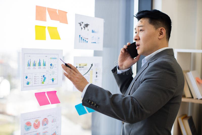 Asian Businessman Analyzing Charts and Discussing Data Insights Stock ...